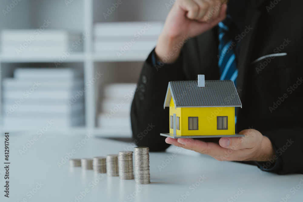 house model ,The hand of the businessman guarding close Money saving ...