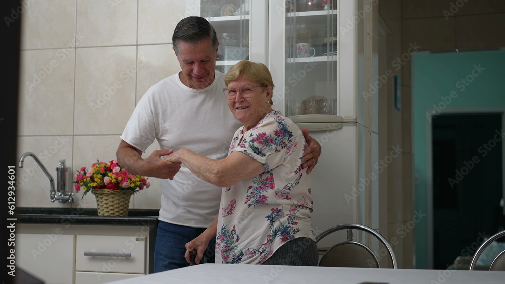 Caretaking moment of middle-aged son helping elderly mother get up from ...