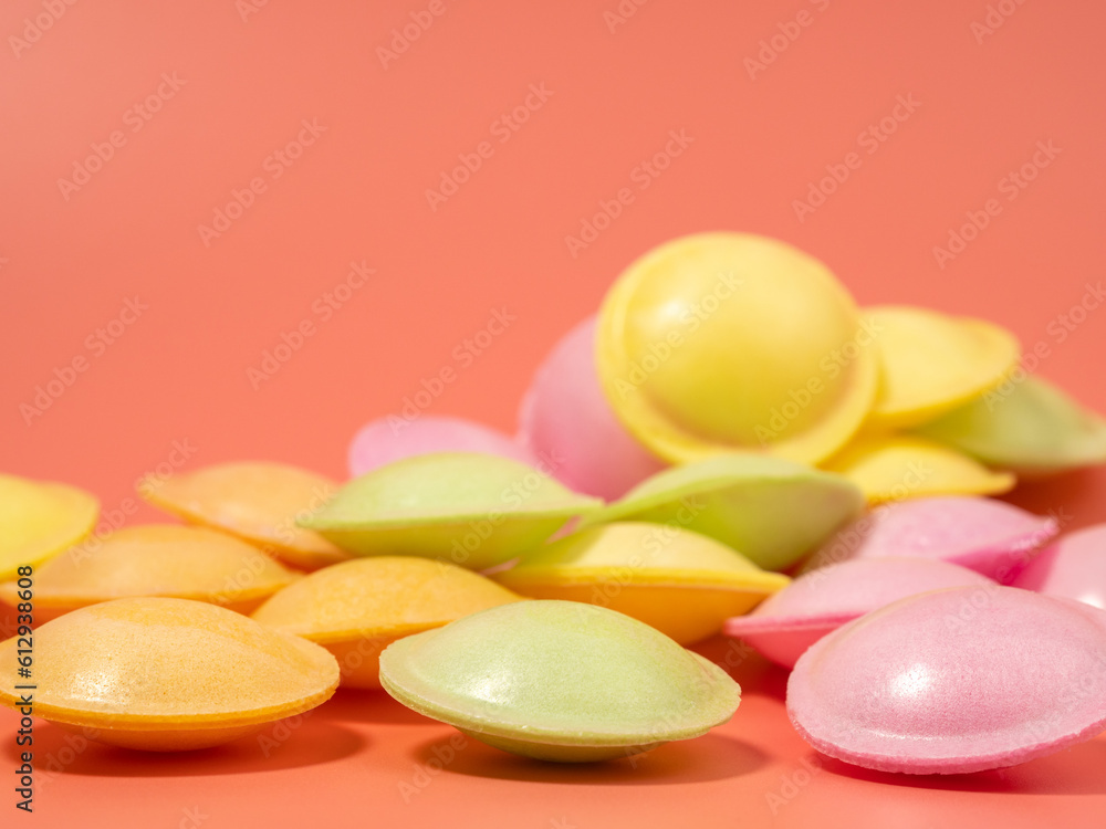 Sweet candies in the shape of a UFO in different colors on a pink ...