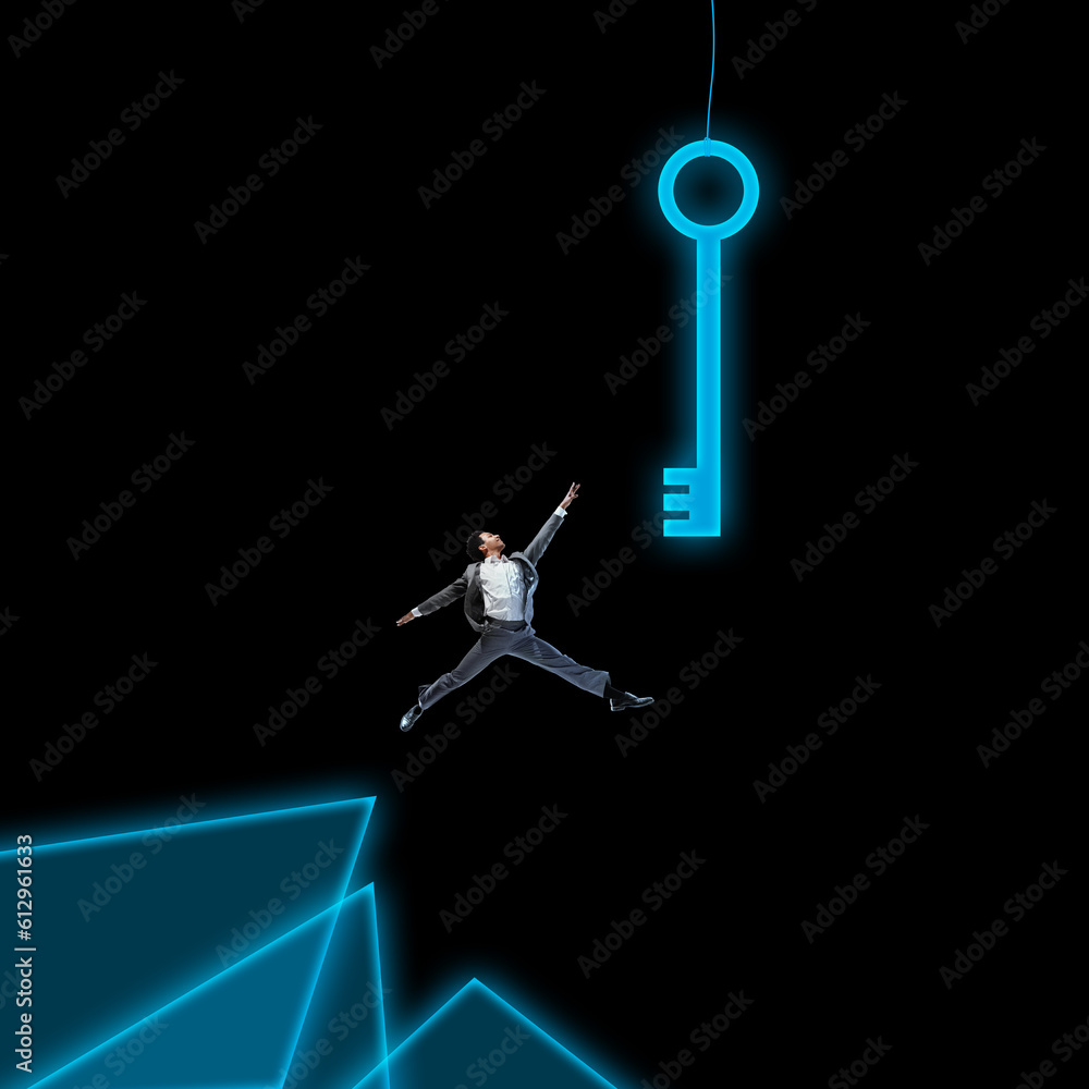 Motivated young employee jumping to catch a key symbolizing new ...