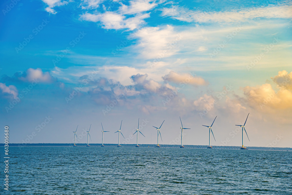 Panoramic view of wind farm at sea, with high wind turbines for ...