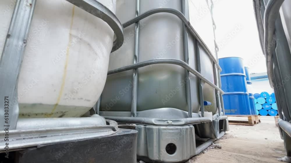 Containers and oil barrels are set up in a chemical storage area inside ...