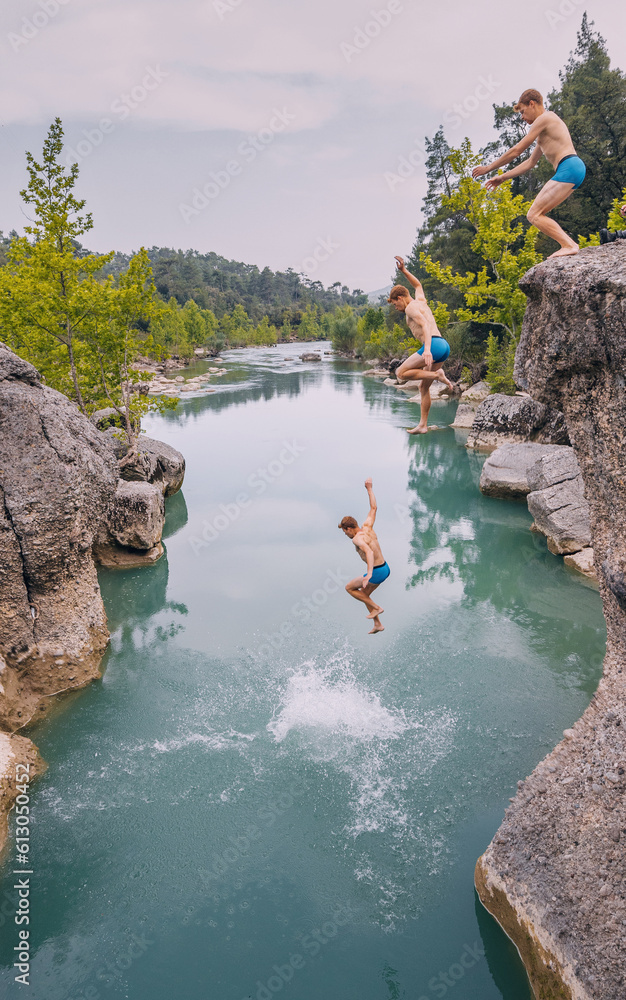 Fearless man jumping from a high cliff to a mountain river. Extreme ...