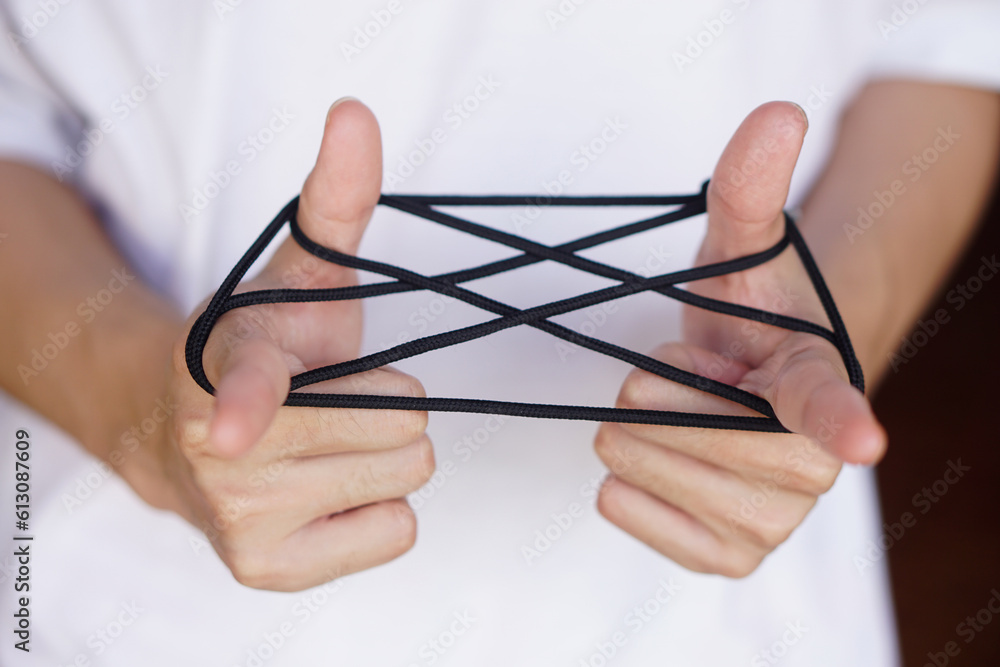Photo Closeup boy hands is playing rope which called cats cradle game ...
