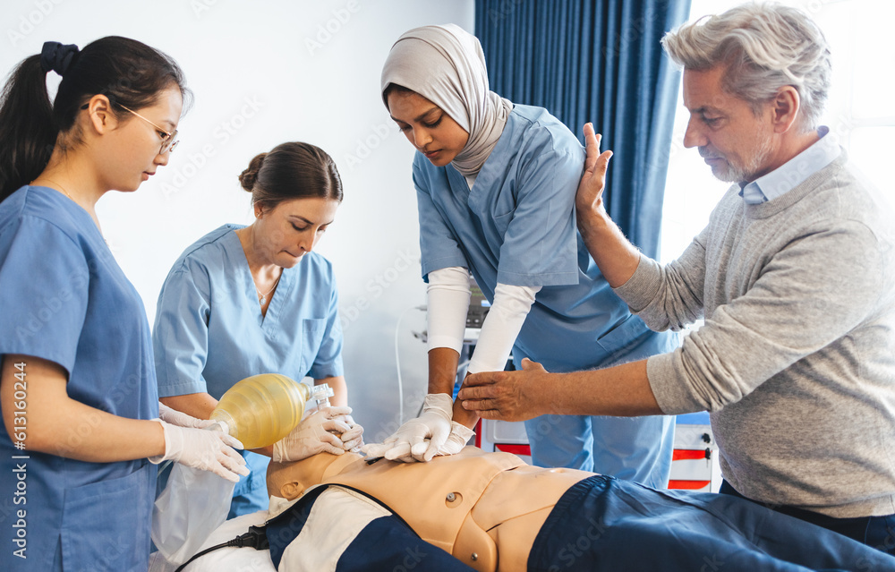 Senior health professional teaching students how to do cpr in medical ...