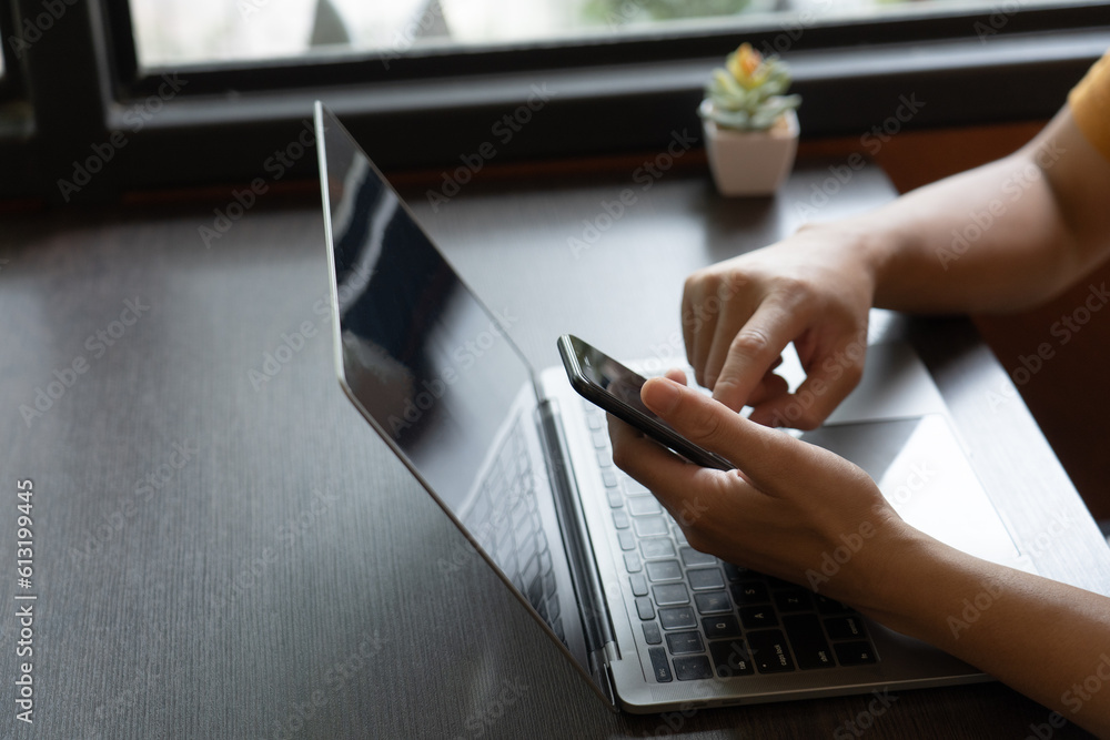 person's hand deftly manipulated both mobile phone and notebook ...