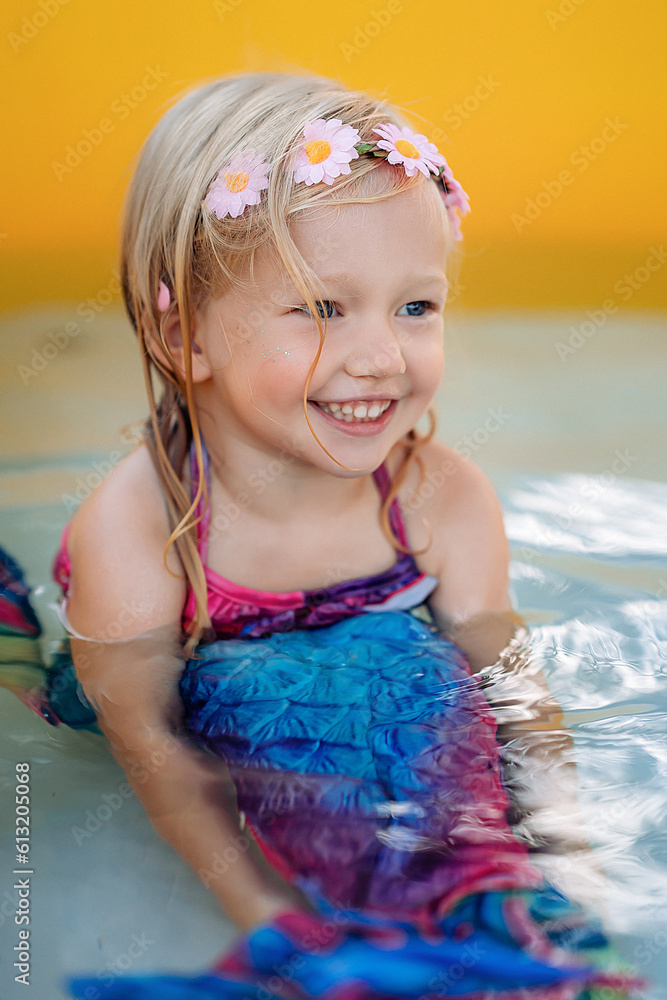 Happy Adorable Little blonde toddler girl with mermaid bathing suit in ...