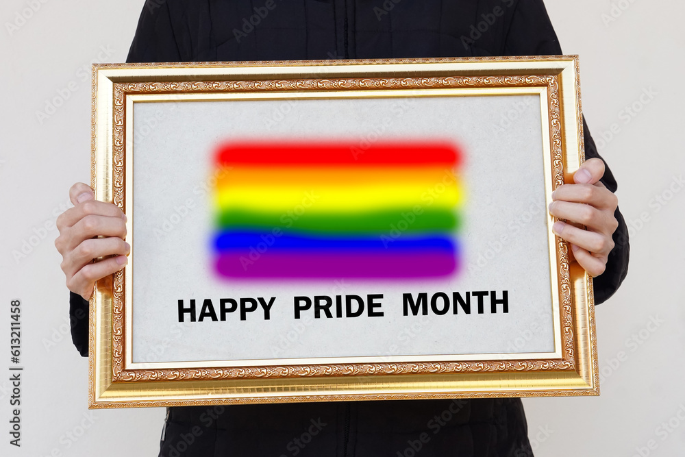 Foto de Closeup gay holds photo frame with rainbow flag and words HAPPY ...