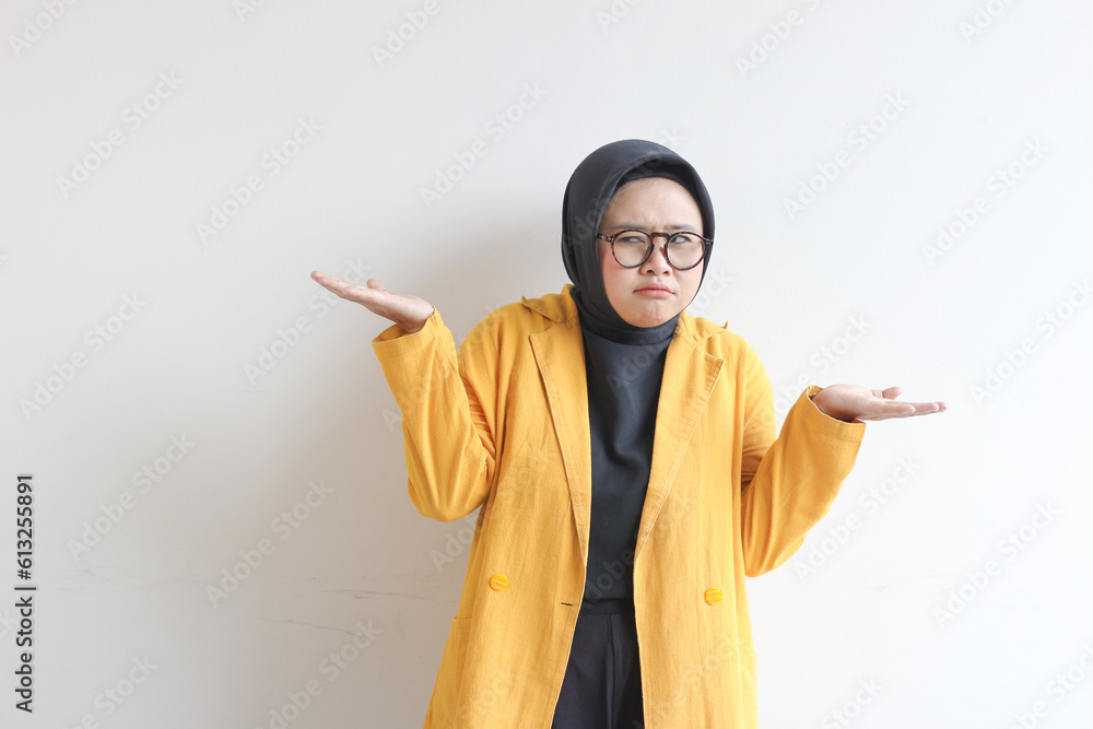 Beautiful young Asian Muslim woman, wearing glasses and yellow blazer ...