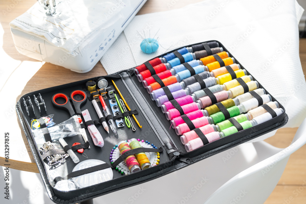 Sewing layout with multicolored spools of thread close-up, needles ...