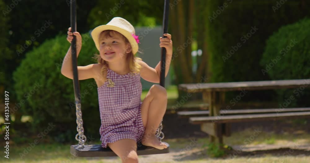 Little girl is swinging on a swing. Amusement park dream concept. Happy ...