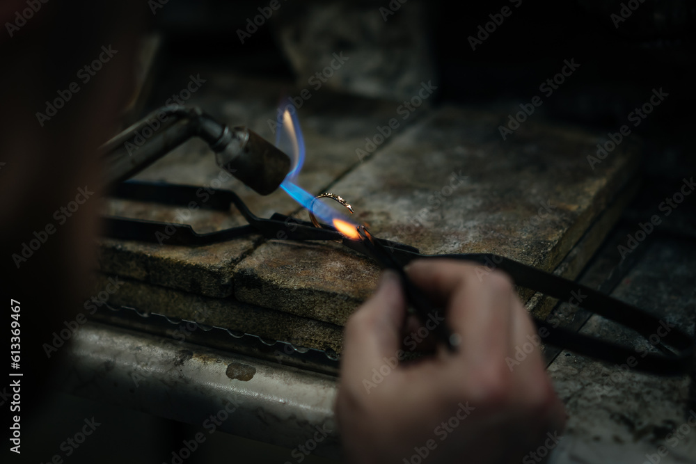 Craftsman is working by using a Gas spraying tool to make a ring Stock ...