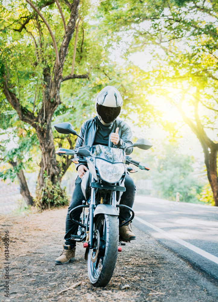 Motorcyclist in safety helmet with thumb up on the road. Biker wearing ...