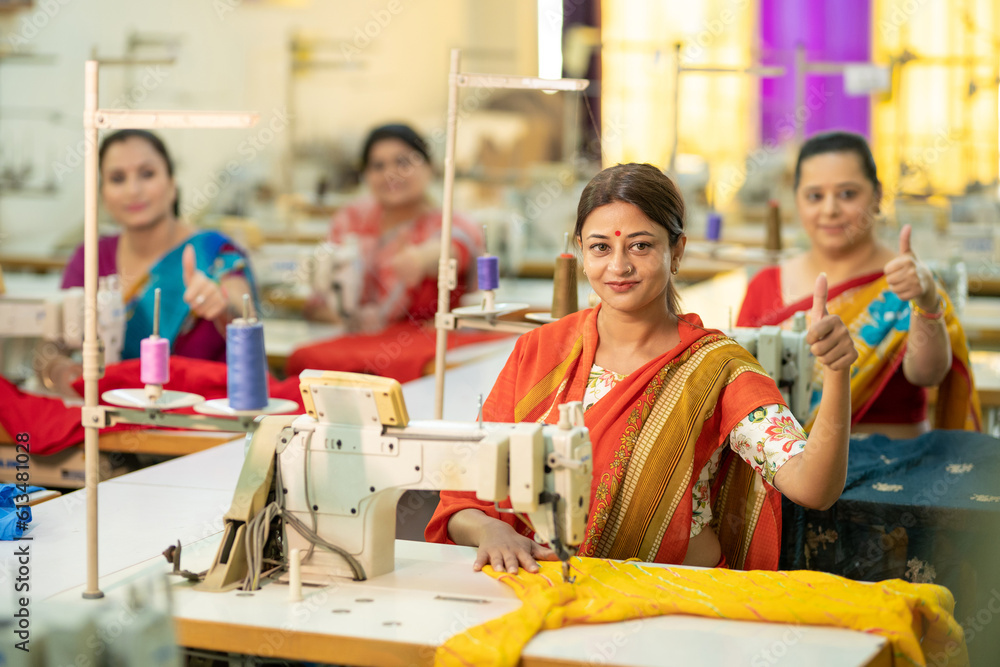 Indian women group showing thumbs up while work on sewing machine at ...