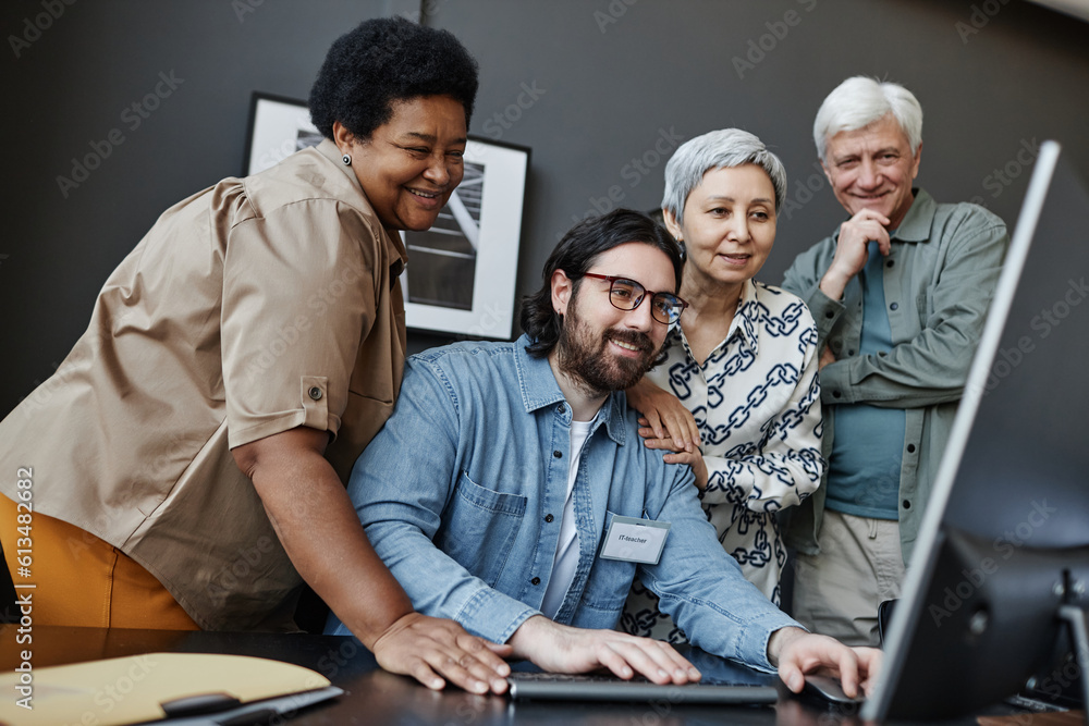Foto de Diverse group of smiling senior people watching man using ...