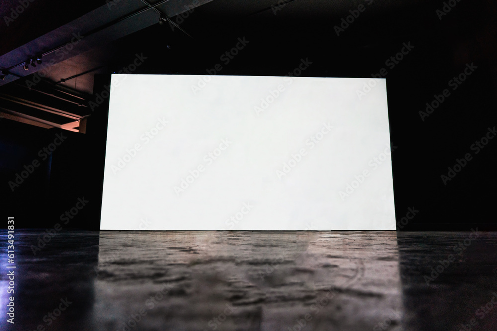 Empty room with blank mockup movie screen monitor standing in dark ...