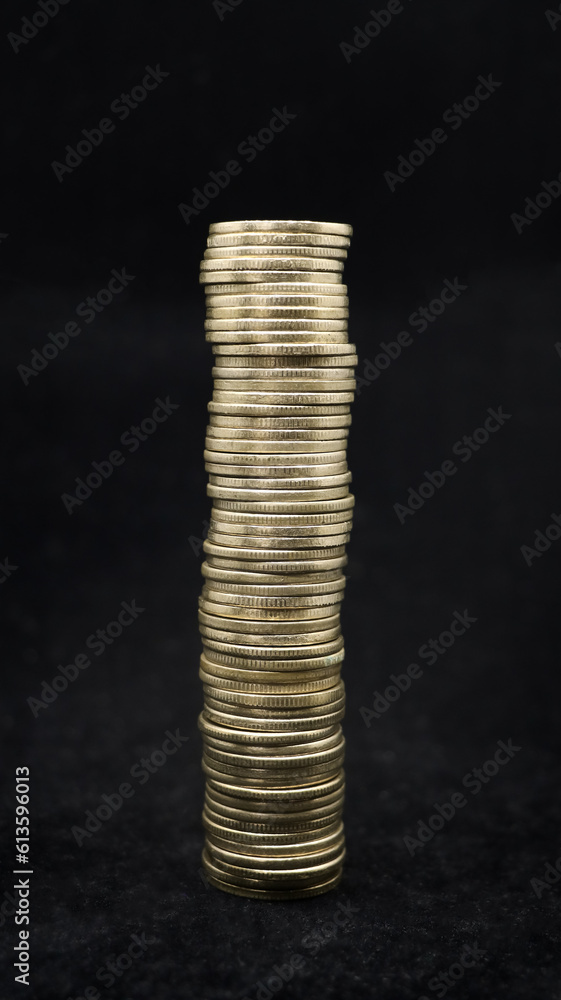 shiny gold coins stacked up and arranged to form a tall tower isolated ...