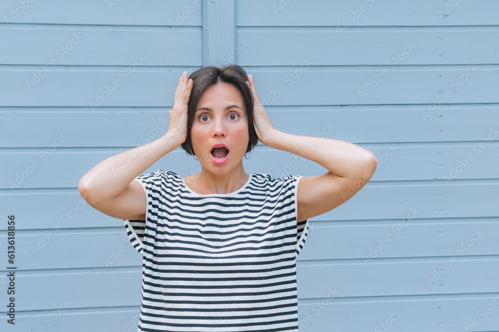 Attractive young woman wearing striped dress reacting with a terrified ...