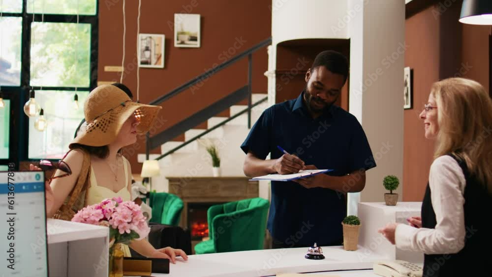Tourists doing check in process with registration forms, filling in ...