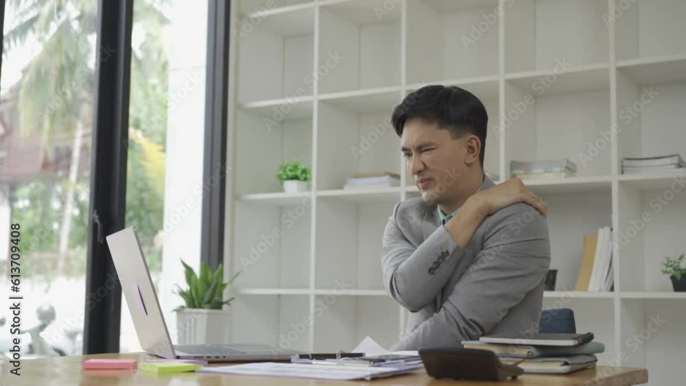 Asian business man Sitting working on laptop with office syndrome ...