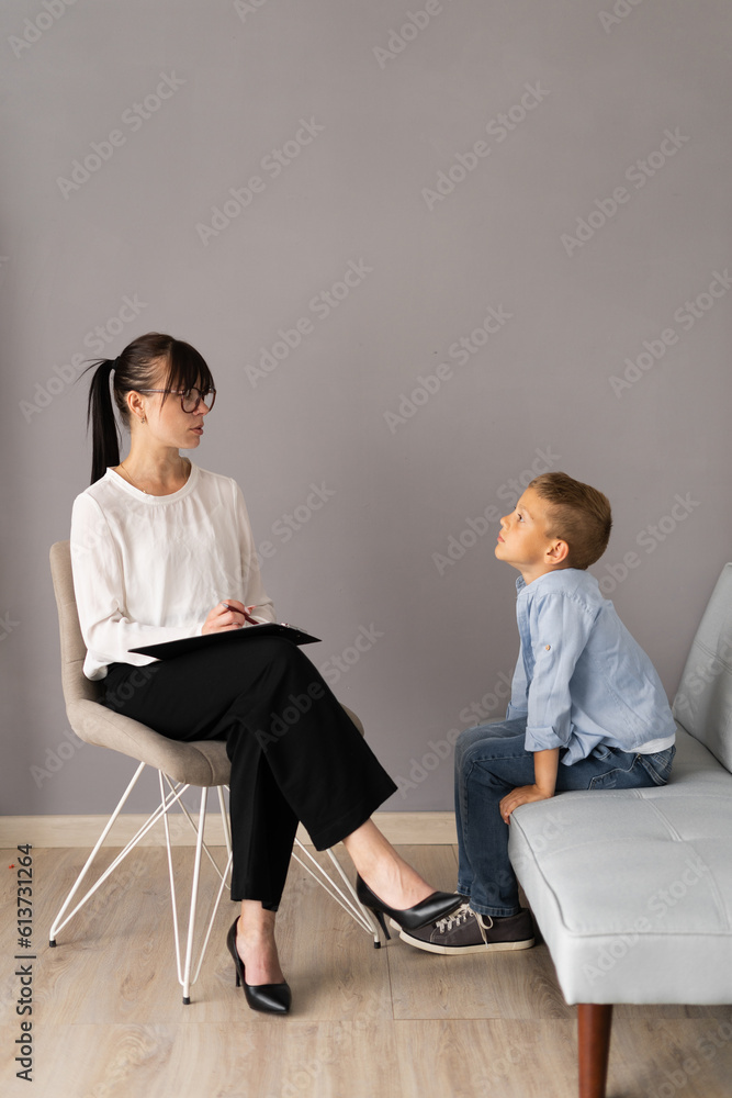 Professional female child psychologist working with a little boy in ...