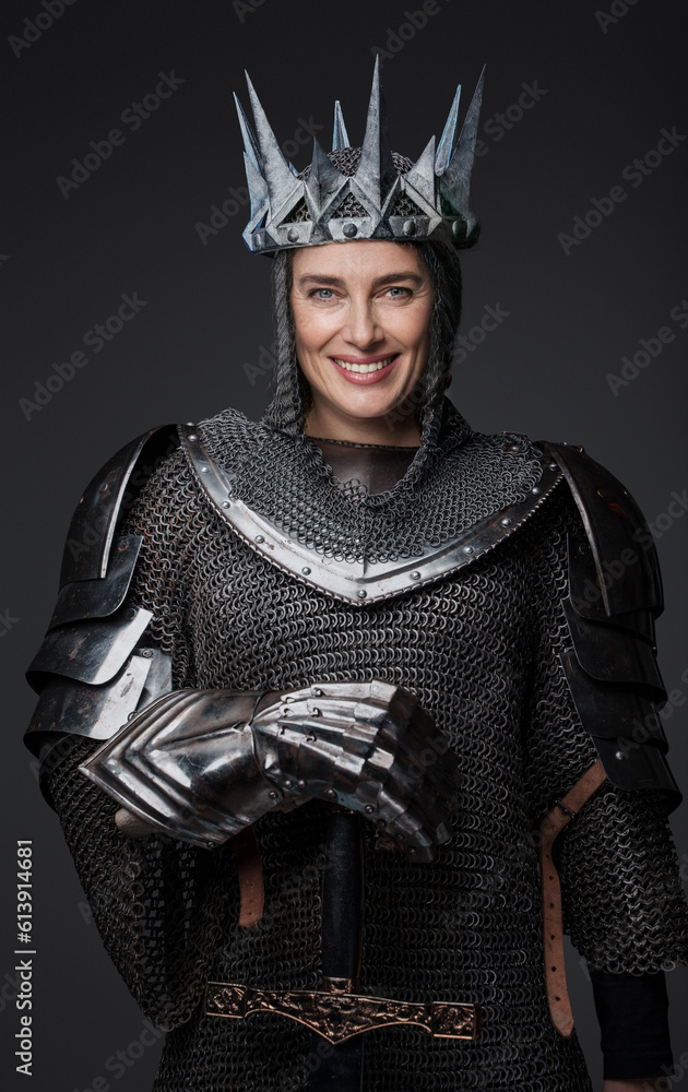 Beautiful queen knight in medieval armor and steel crown exudes joy and ...