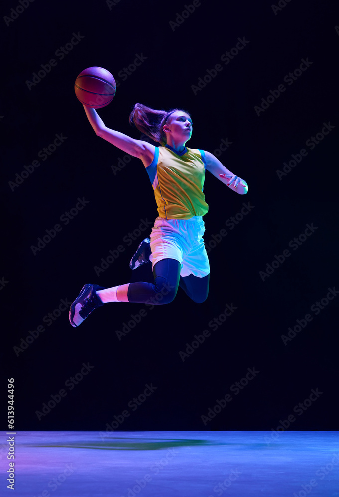 Slam dunk. Basketball player in motion, young girl jumping with ball ...