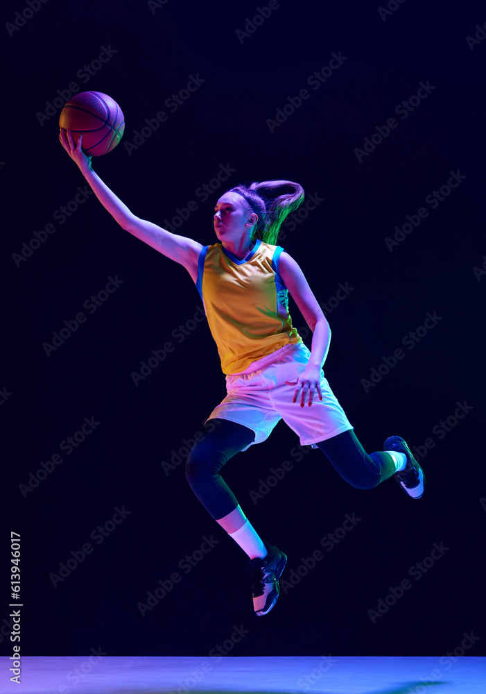 Slam dunk. Basketball player in motion, young girl jumping with ball ...