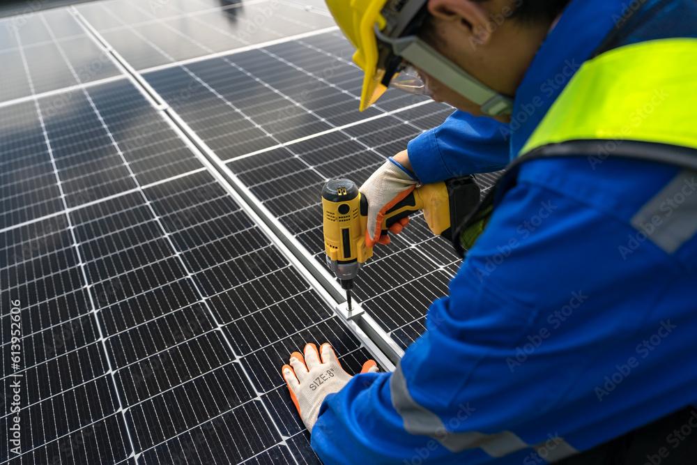 Technicians are installing solar panels on factory roof, with Asian ...