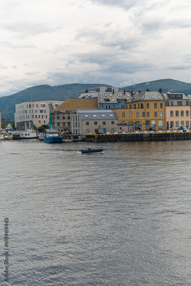 Boat setting sail at sunset. Boat going through water channel in town ...