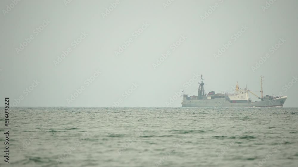 Big fishing boat trawling and catching fish as it crosses the sea at ...
