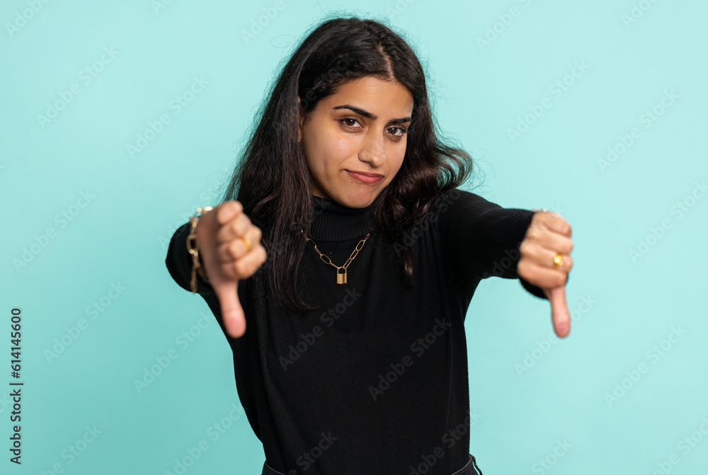 Dislike. Upset unhappy indian woman in sweater showing thumbs down sign ...