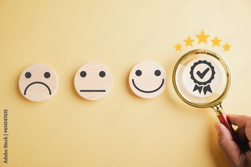 Hand holds magnifier, focusing on happy smiley face icon among various ...