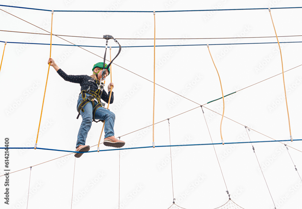 Teenage teen girl in climbing harness equipment, green sports safety ...