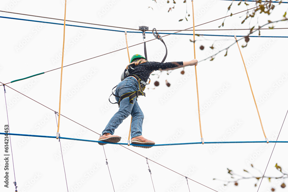 Teenage teen girl in climbing harness equipment, green sports safety ...