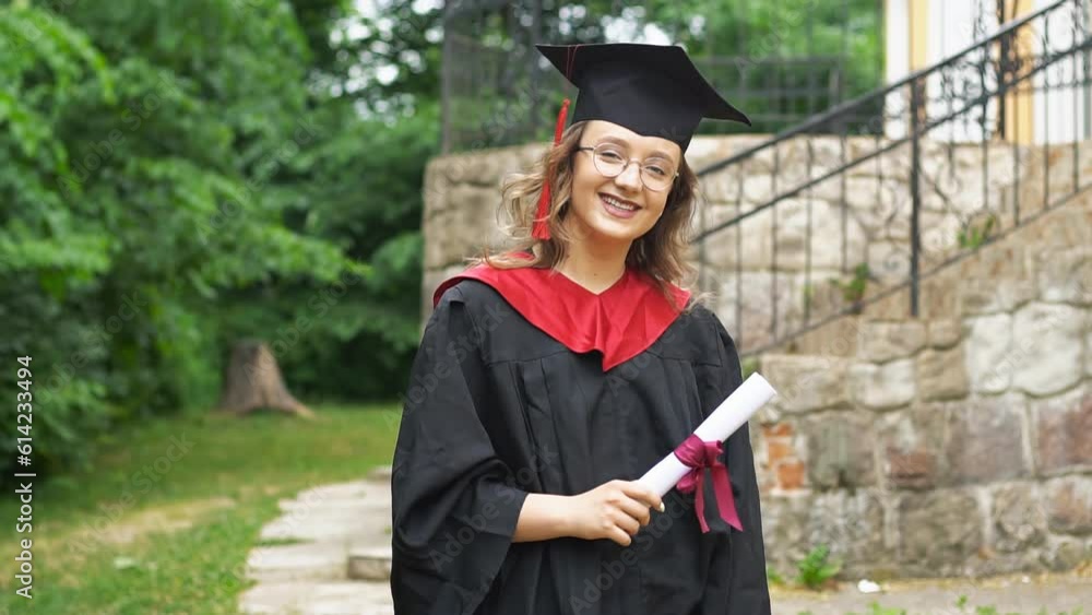 Portrait of a beautiful smiling graduated student girl in black ...