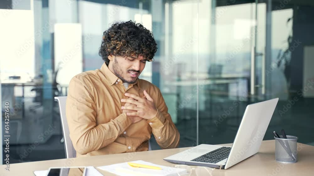 A young employee has a heart attack while working on a laptop while ...