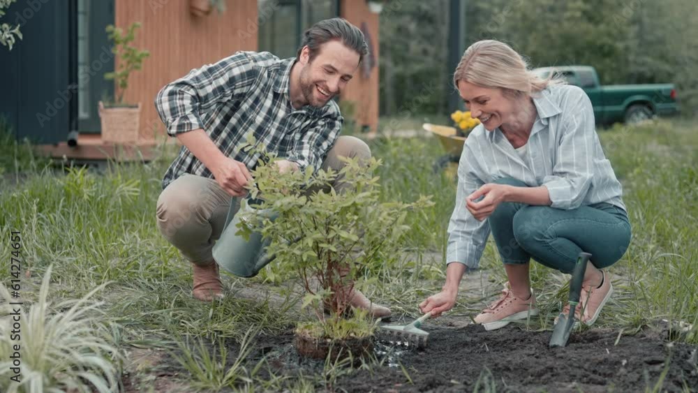 Two Caucasian people working together in garden. Beautiful couple ...