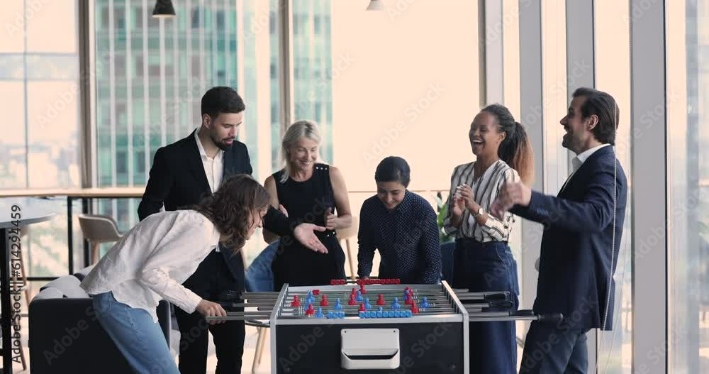 Joyful excited employee beating office friend in tabletop football ...
