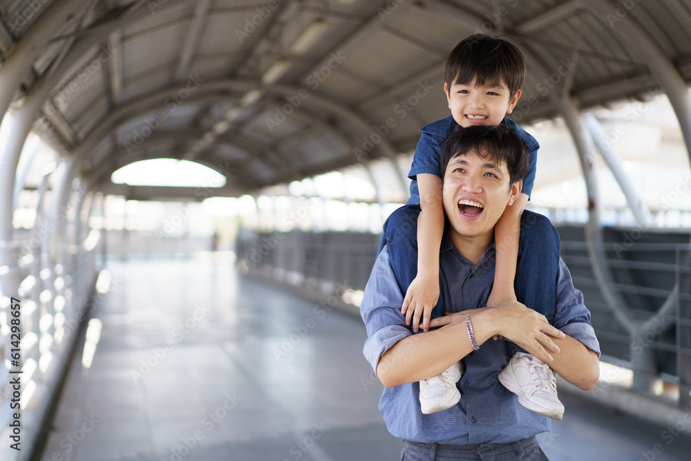 Happy joyful Asian man and lovely son traveling together in the city ...