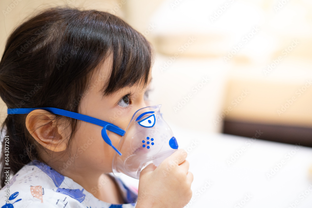Little asian girl sick making inhalation with nebulizer to reduce ...