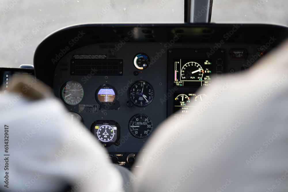 Helicopter pilot at controls with instrument panel showing airspeed and ...