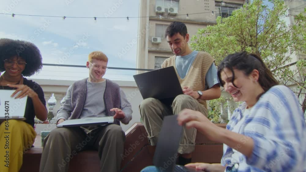 Gen Z business people sitting at outdoor coworking space, stacking ...