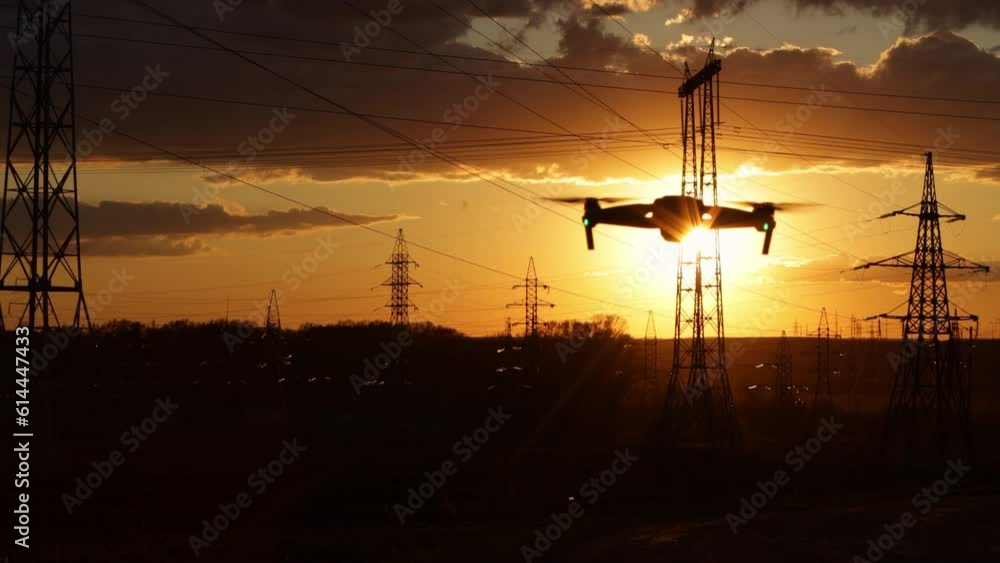 The silhouette of a drone against the background of sunset and an ...