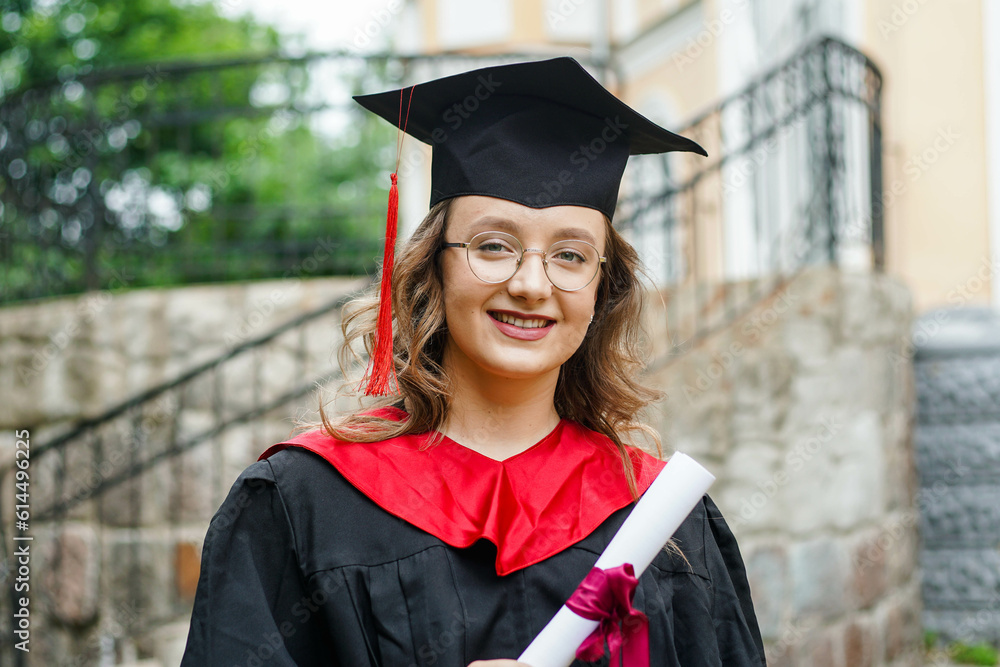 Portrait of a beautiful smiling graduated student girl in black ...