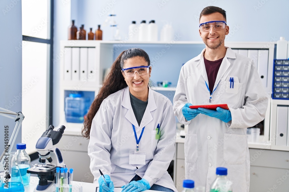 Man and woman wearing scientist uniform using touchpad write on ...