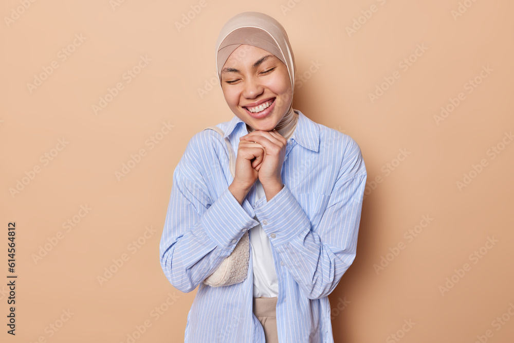 Studio shot of happy Muslim woman has genuine smile which shines with ...
