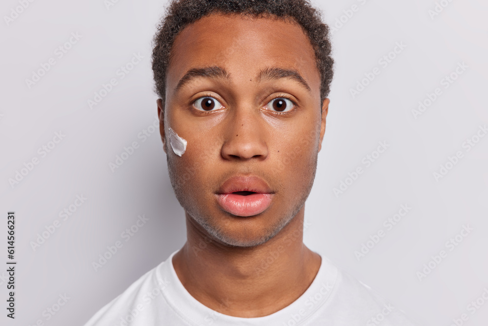 Close up shot of handsome middle aged dark skinned man applies face ...