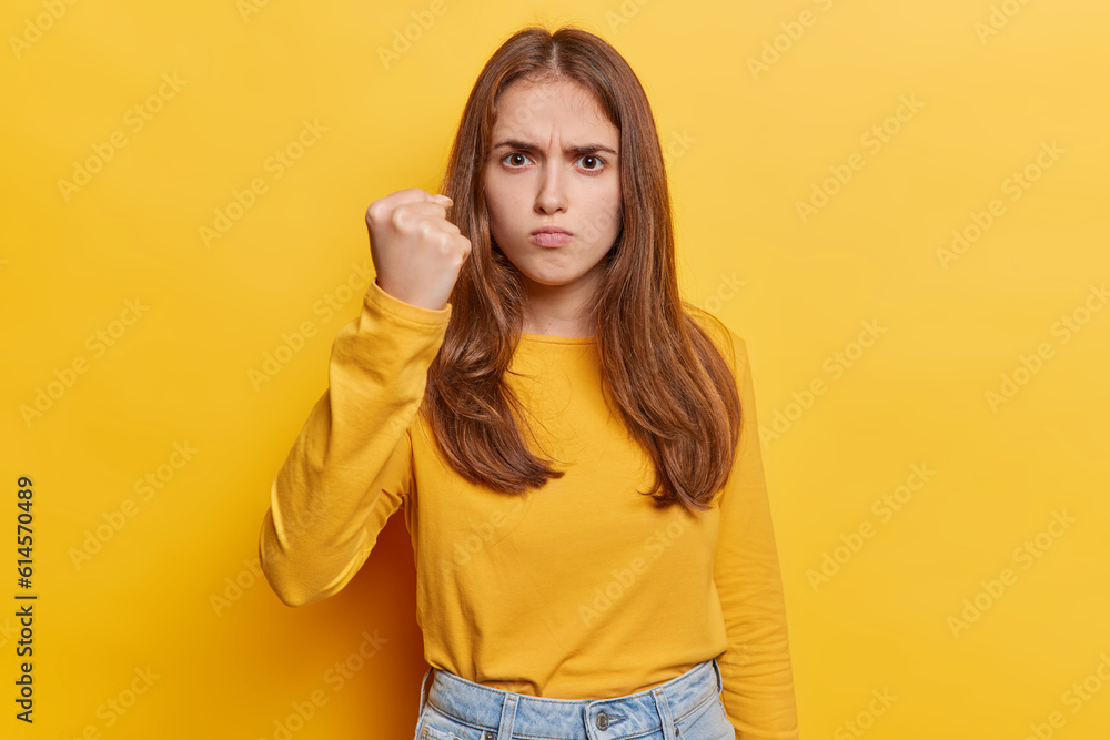 Horizontal shot of angry woman commands attention clenches her fist ...
