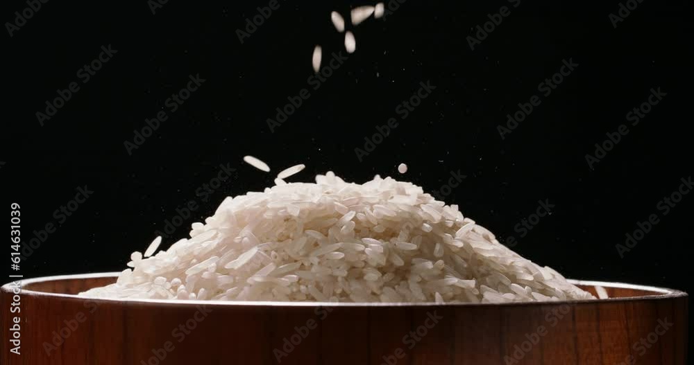 Rice being poured raw wooden cup side view black background 4K footage ...